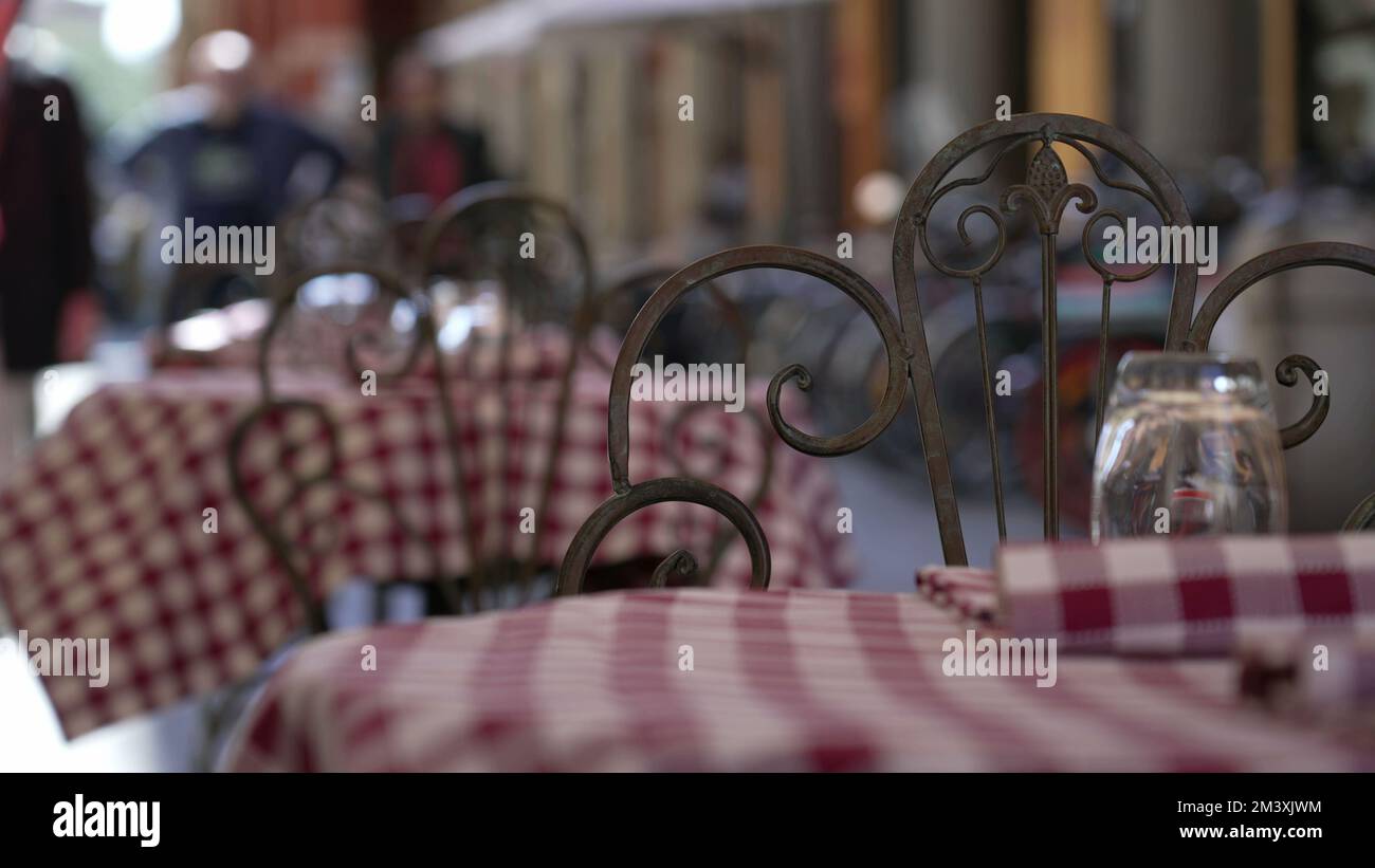Empty Italian restaurant table in European street with napkin and ...