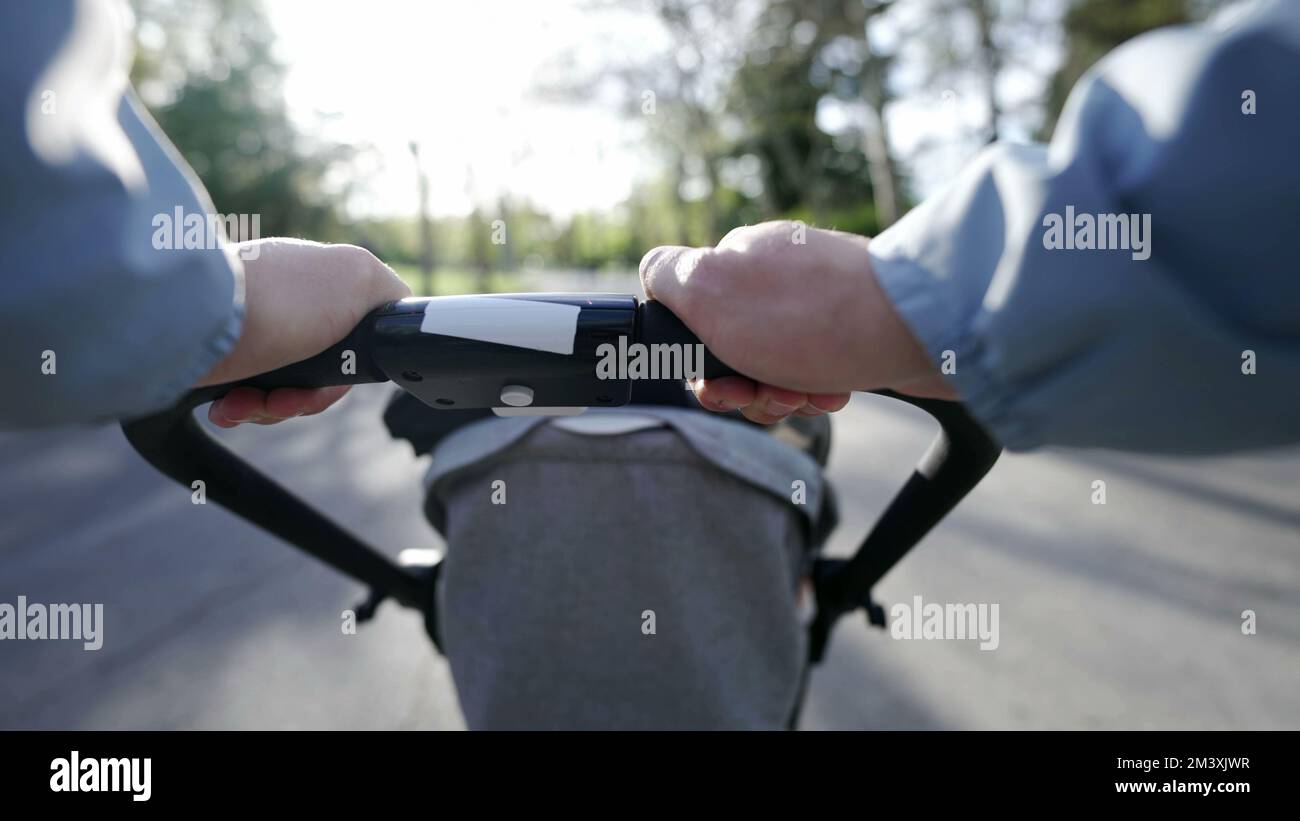 Hands holding stroller POV of mother walking outside in nature with ...