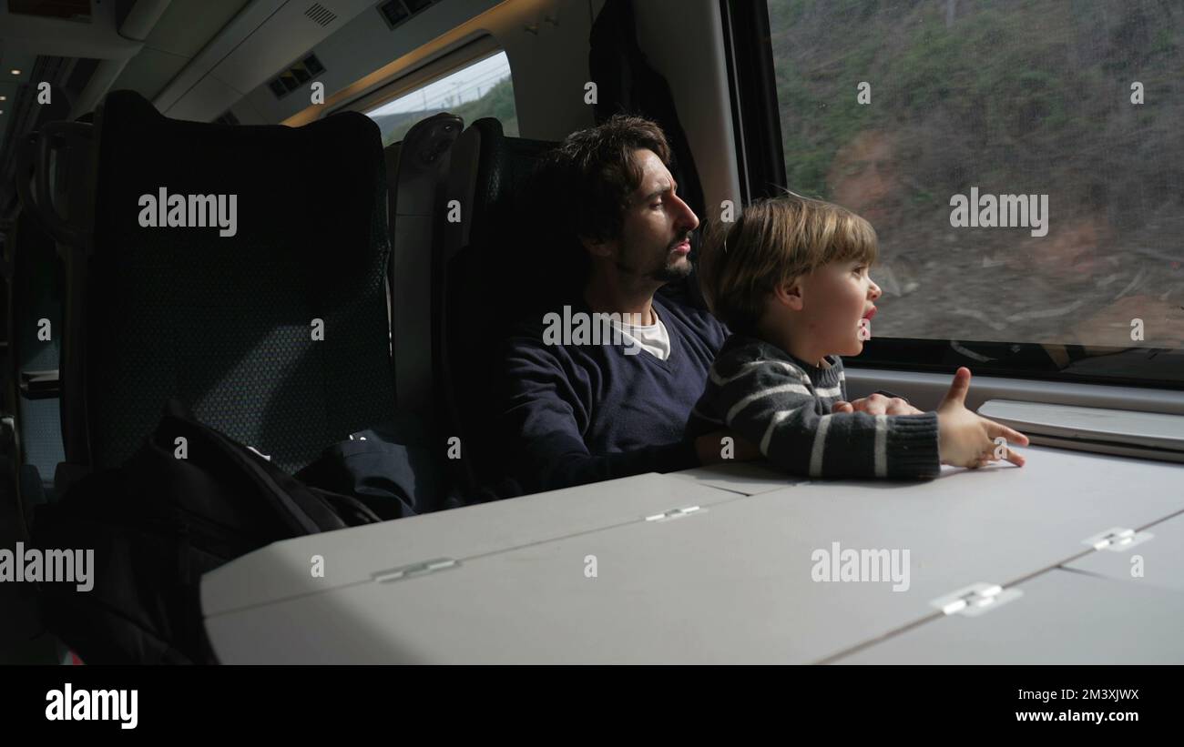 Father and son traveling by train together. Passengers seated by high ...