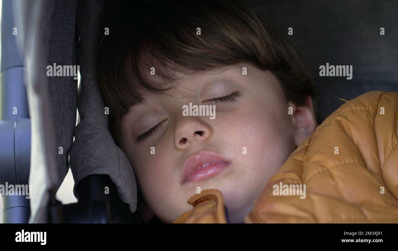 Closeup child face sleeping inside strolller. 2 year old kid asleep ...