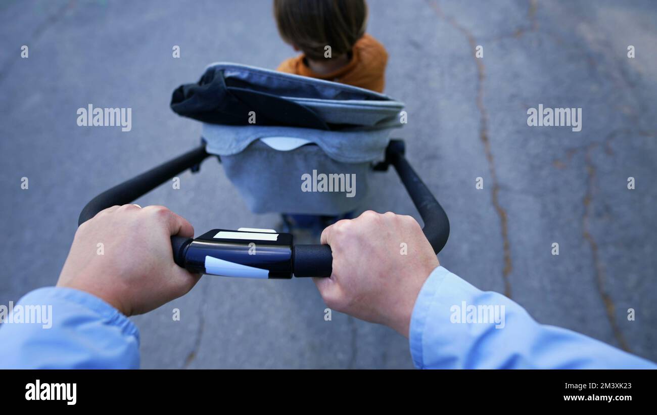 Mother POV pushing stroller outside at park. Hands closeup point of ...