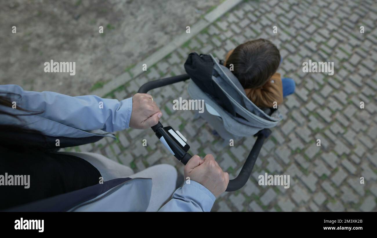 Mother POV pushing stroller outside at park. Hands closeup point of ...