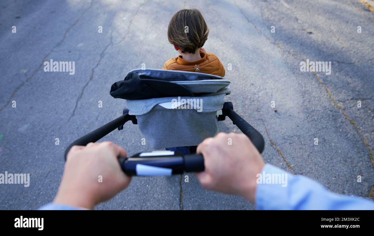 Mother POV pushing stroller outside at park. Hands closeup point of ...