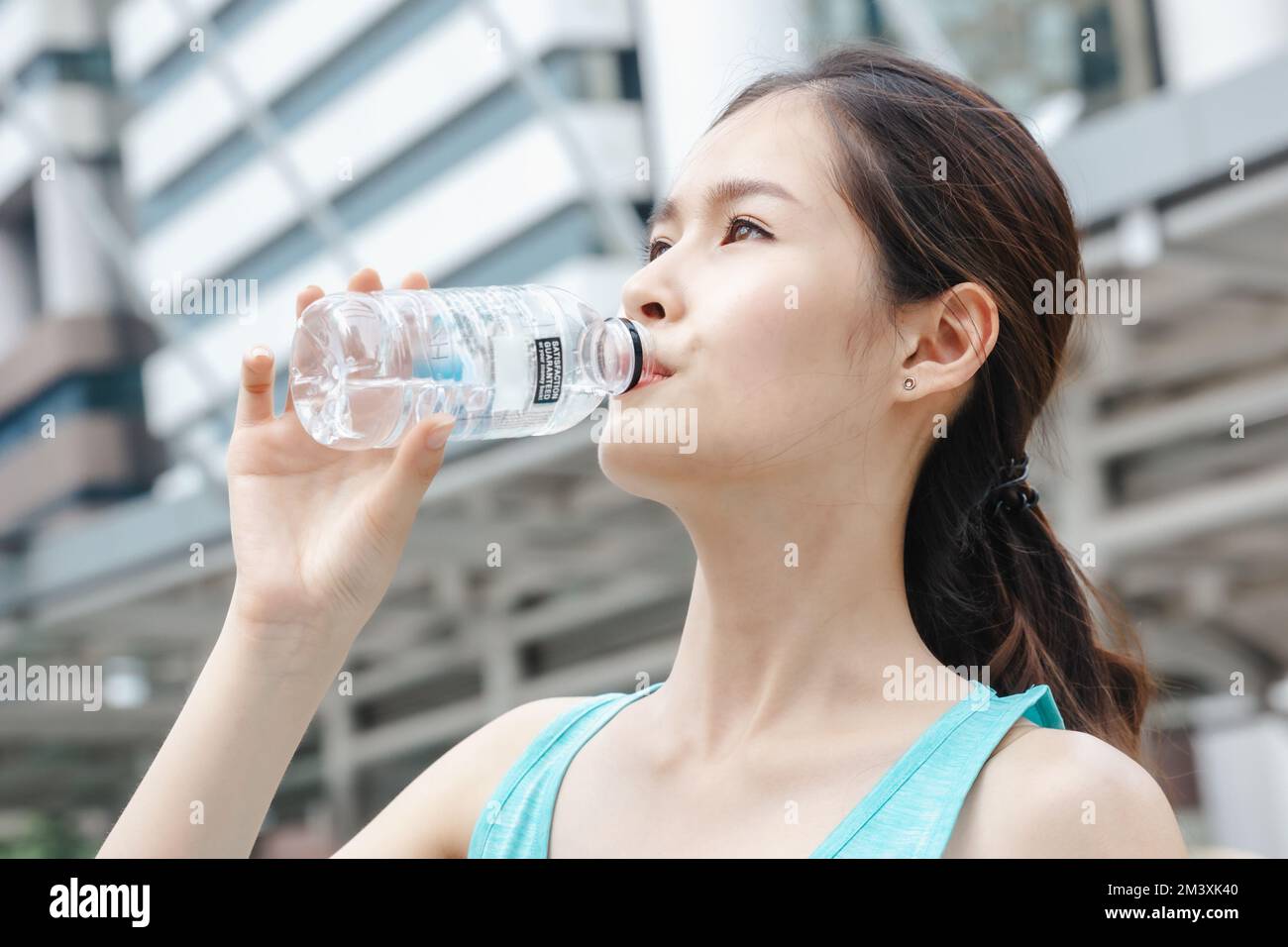 Asian lady drinking water sport healthy lifestyle outdoors in building ...