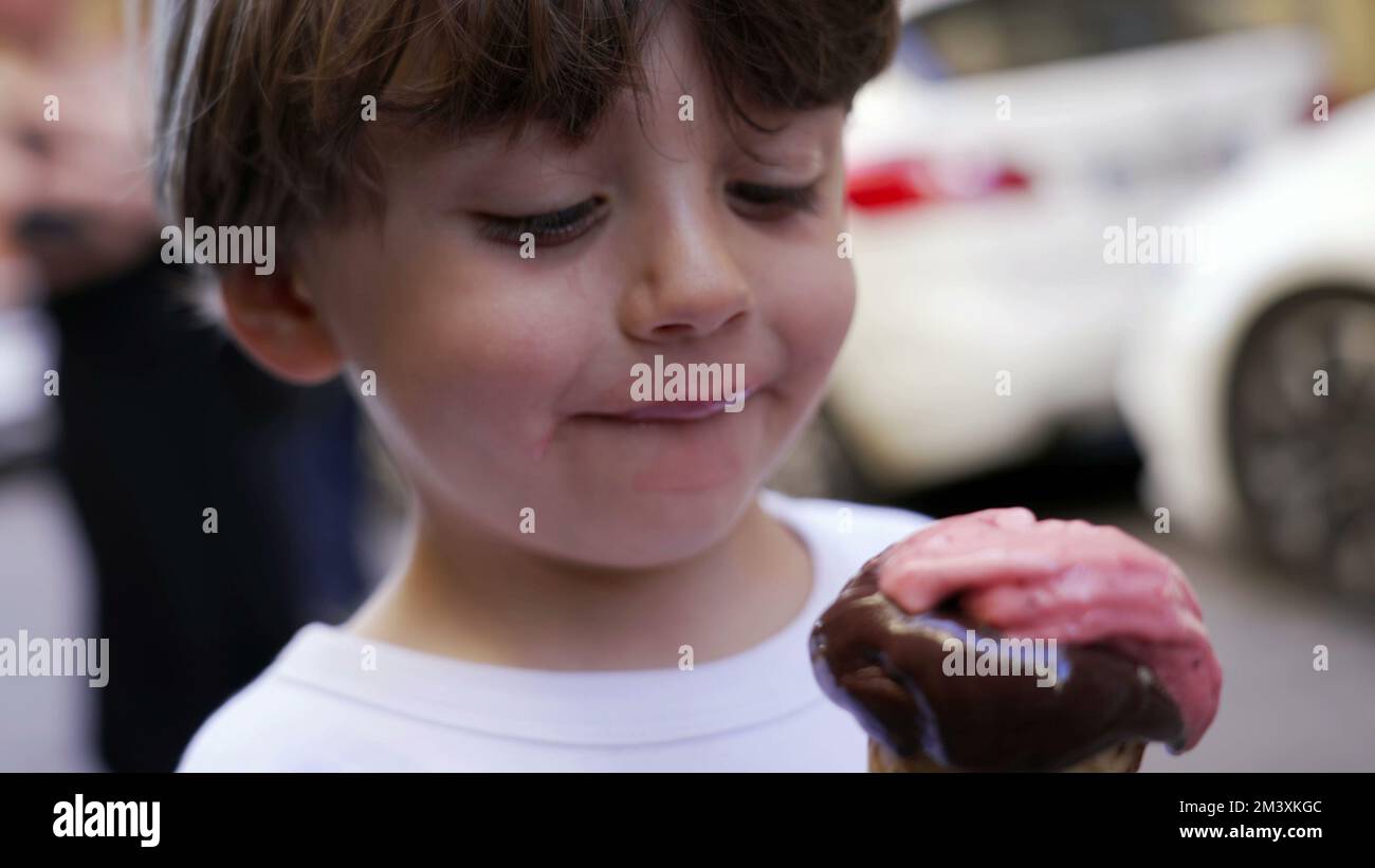One little boy eating icecream outside. Portrait face closeup of a ...