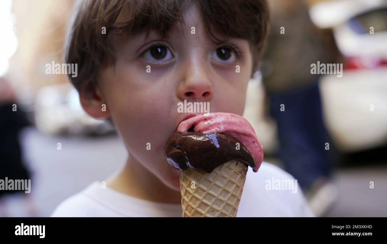 One little boy eating icecream outside. Portrait face closeup of a ...