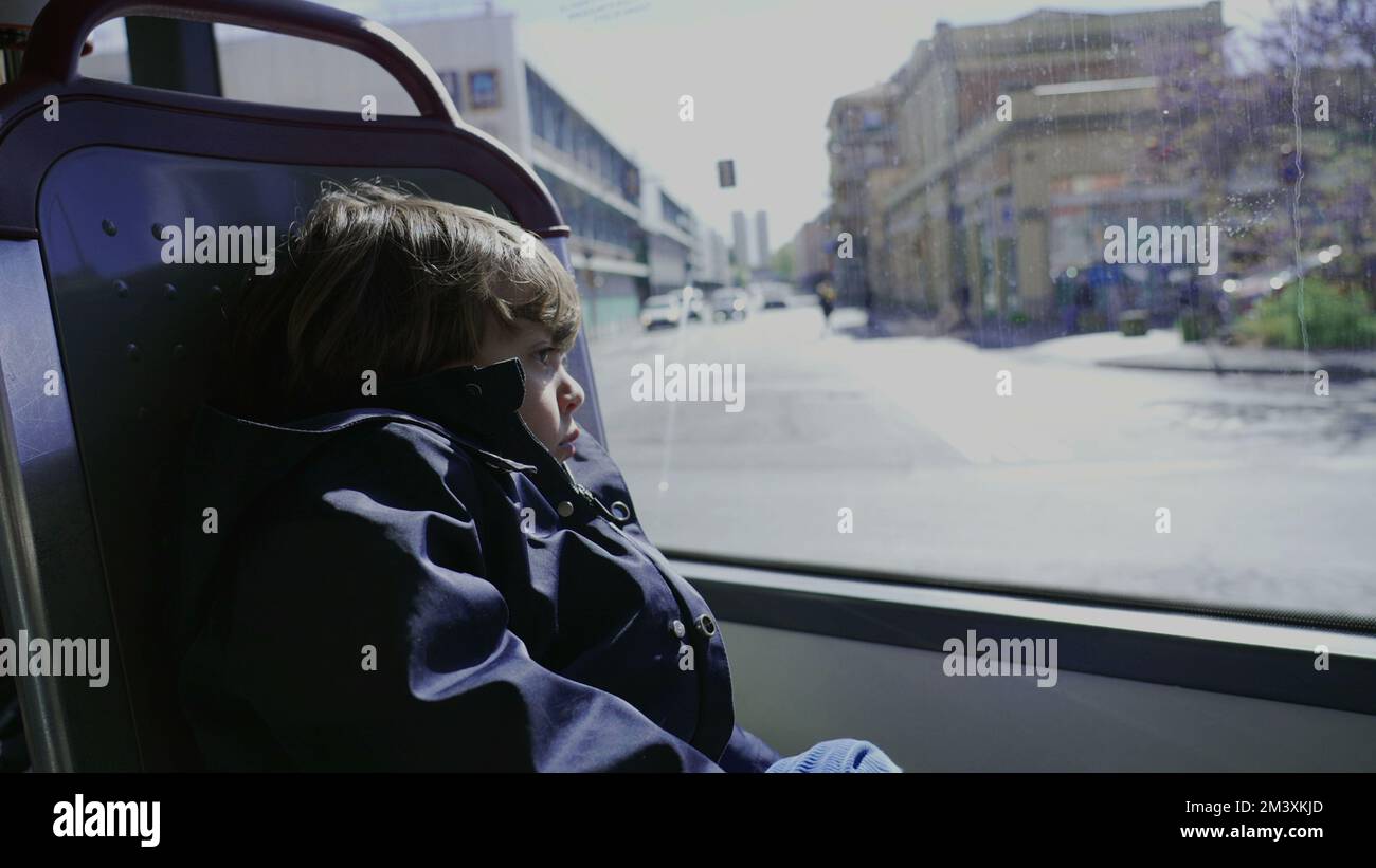 Sad child inside bus public transportation. One depressed little boy ...