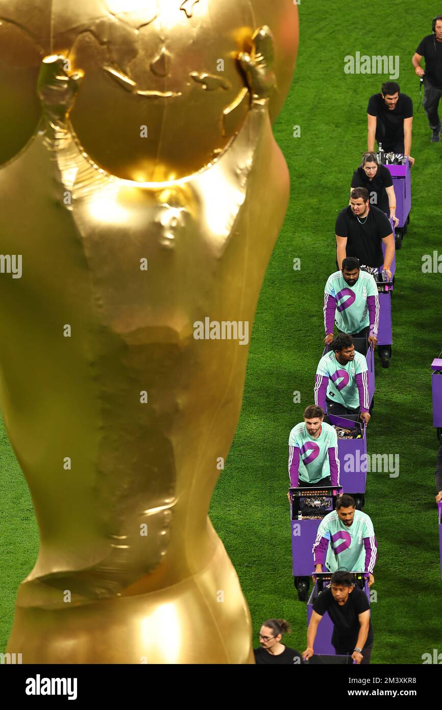 Doha, Qatar. 17th Dec, 2022. Staff members carry a replica of the FIFA ...