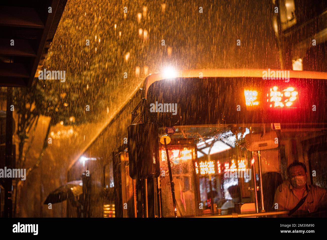 A bus driving on the street in a rainstorm night Stock Photo - Alamy