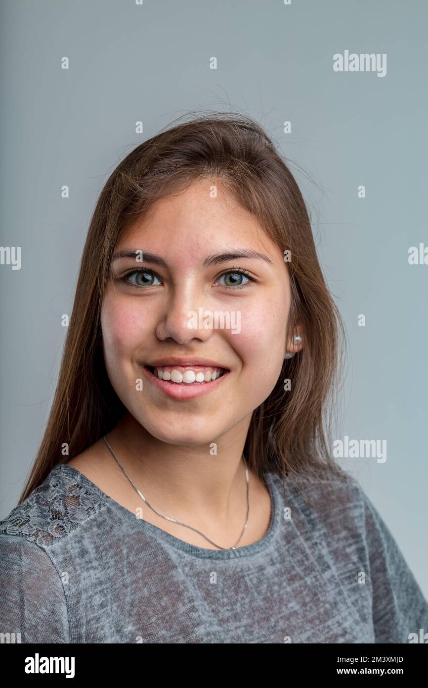 Vertical portrait of the face of a young girl with light eyes and long ...