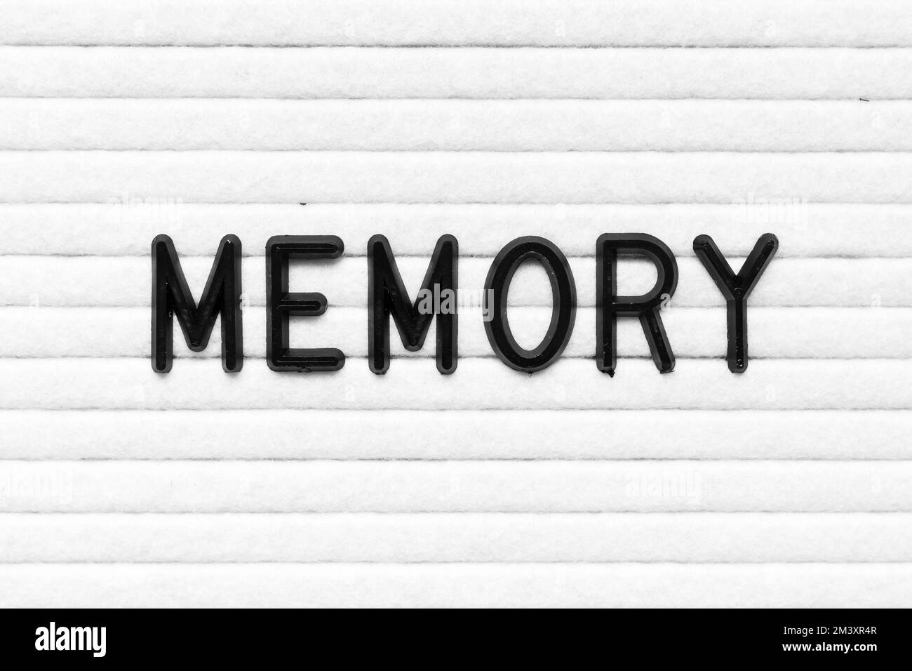 Black alphabet letter in word memory on white felt board background ...