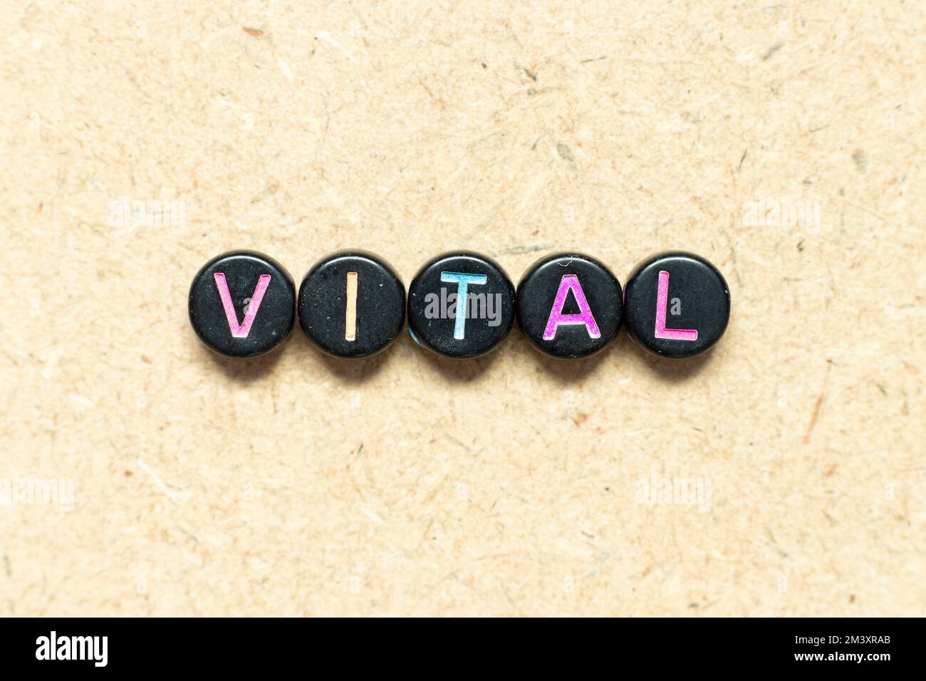Black color round bead in word vital on wood background Stock Photo - Alamy