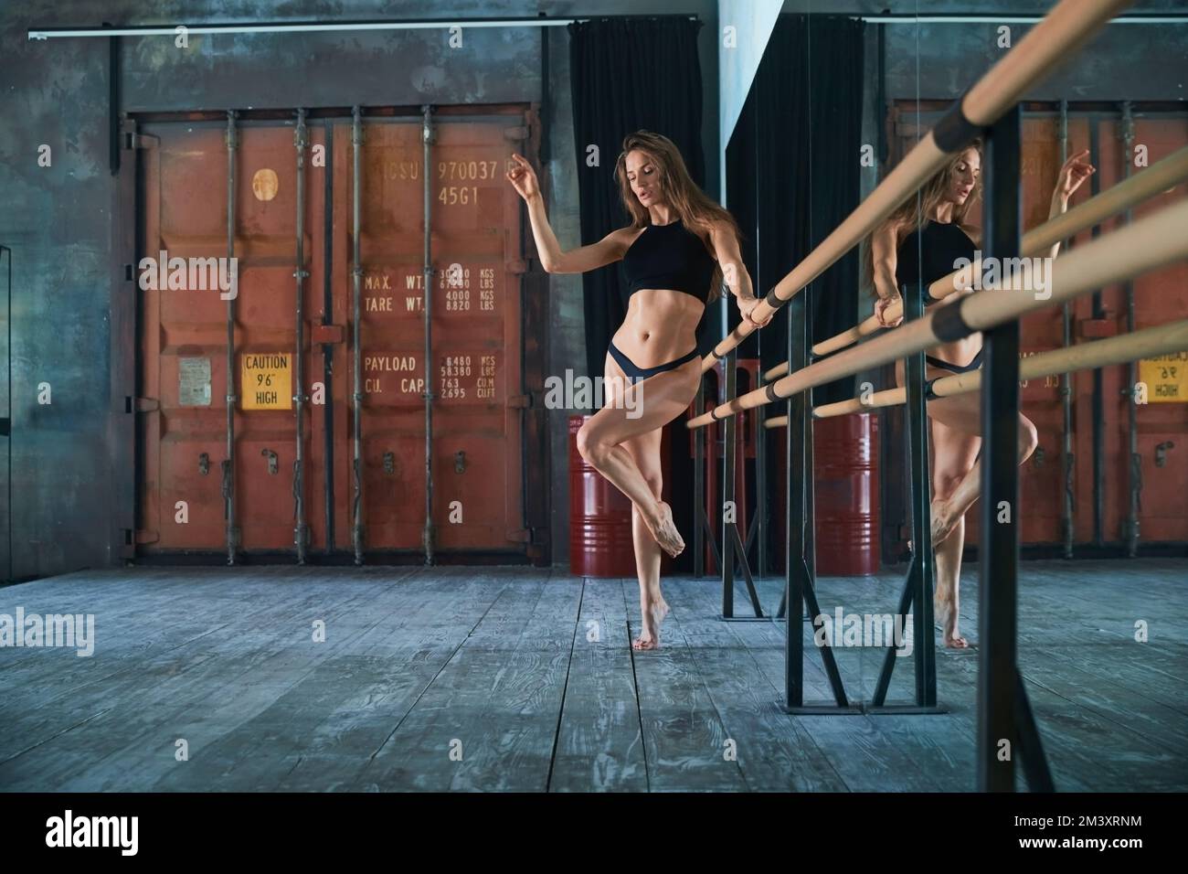 a beautiful girl of athletic build, a ballerina stands at a ballroom ...