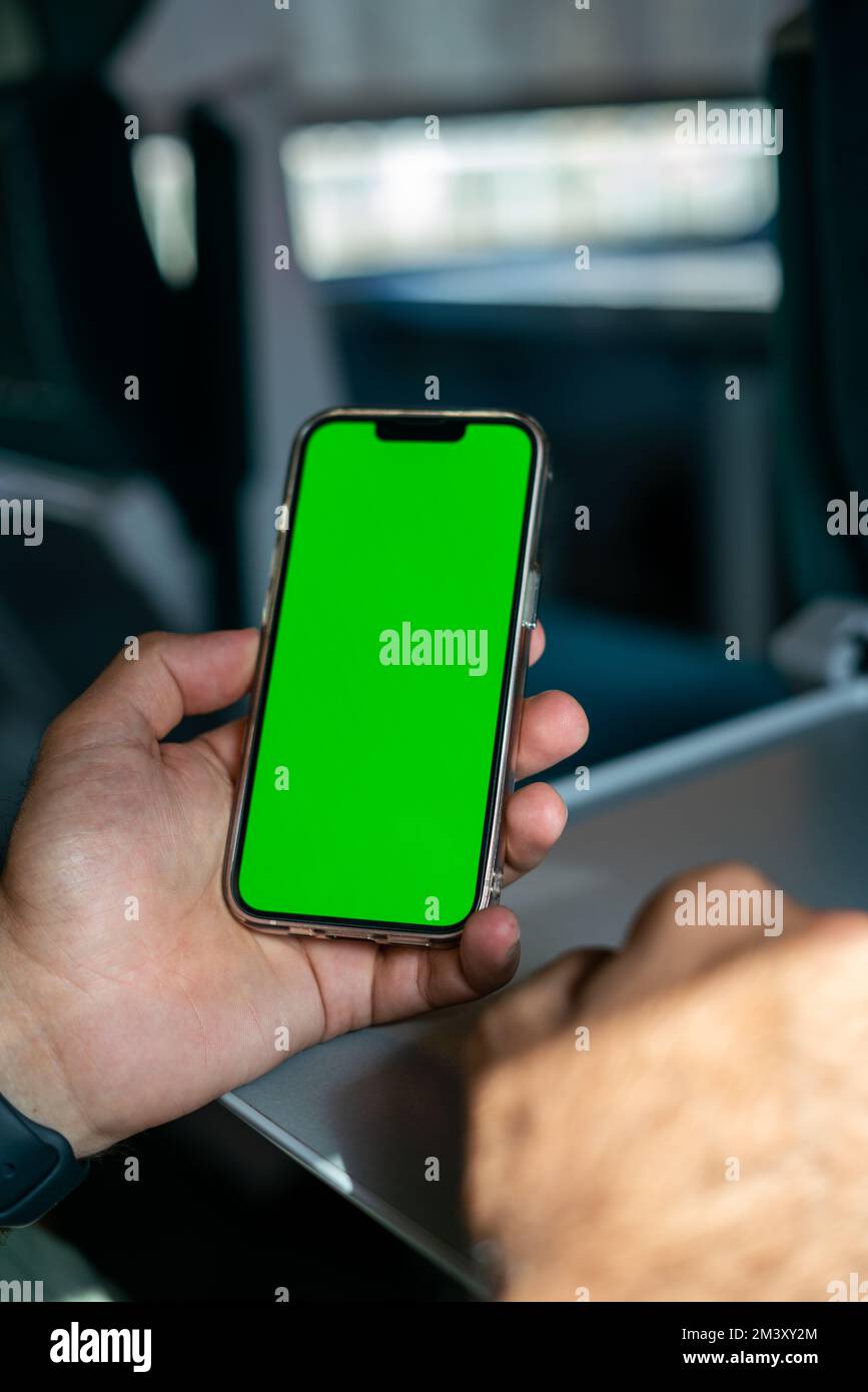 Unidentified man holding a smartphone with green screen Stock Photo - Alamy