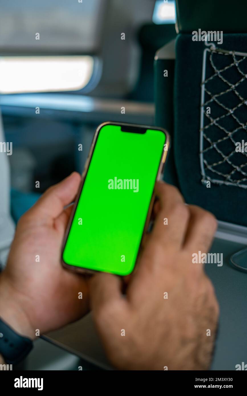 Unidentified man holding a smartphone with green screen Stock Photo - Alamy