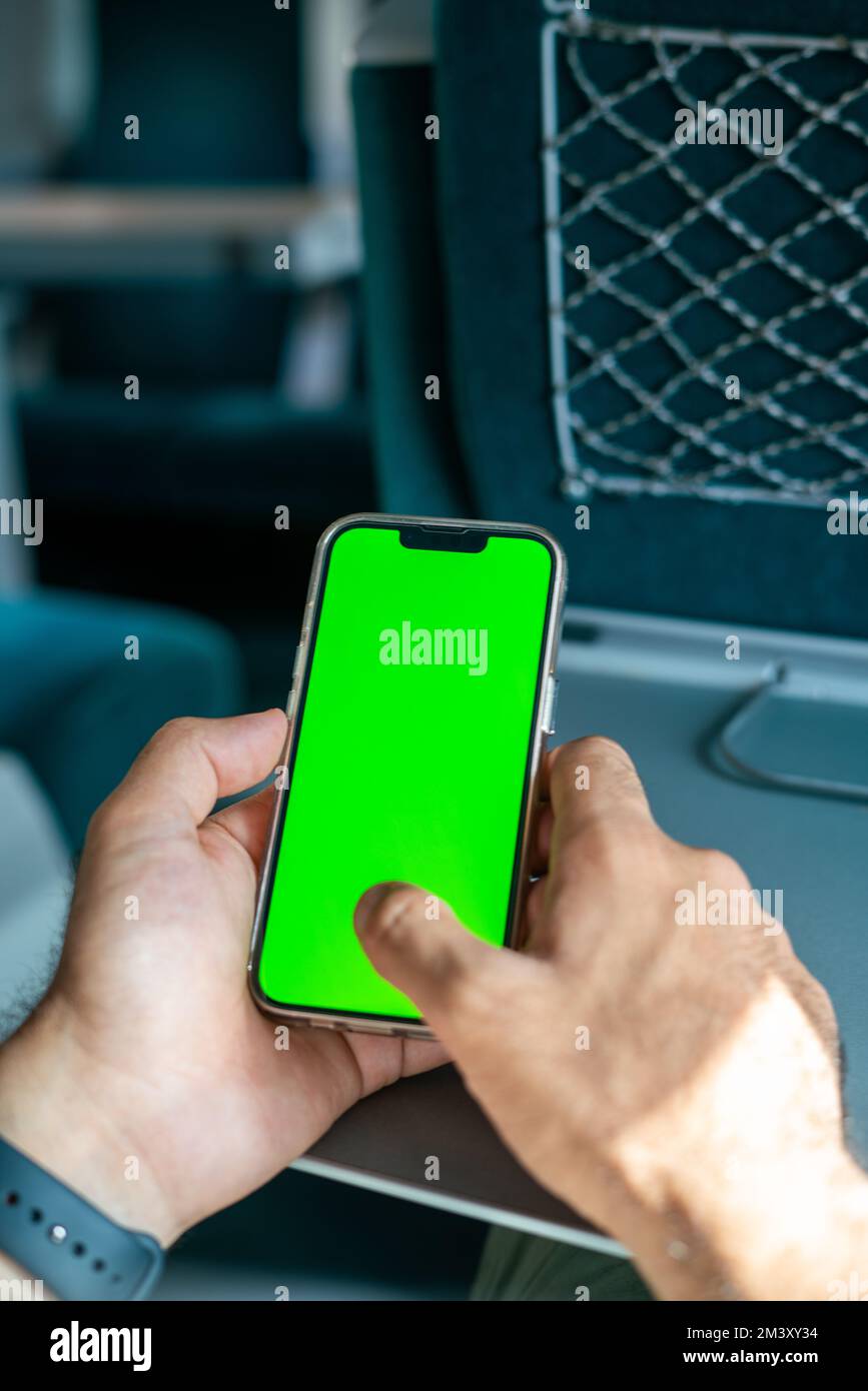 Unidentified man holding a smartphone with green screen Stock Photo - Alamy