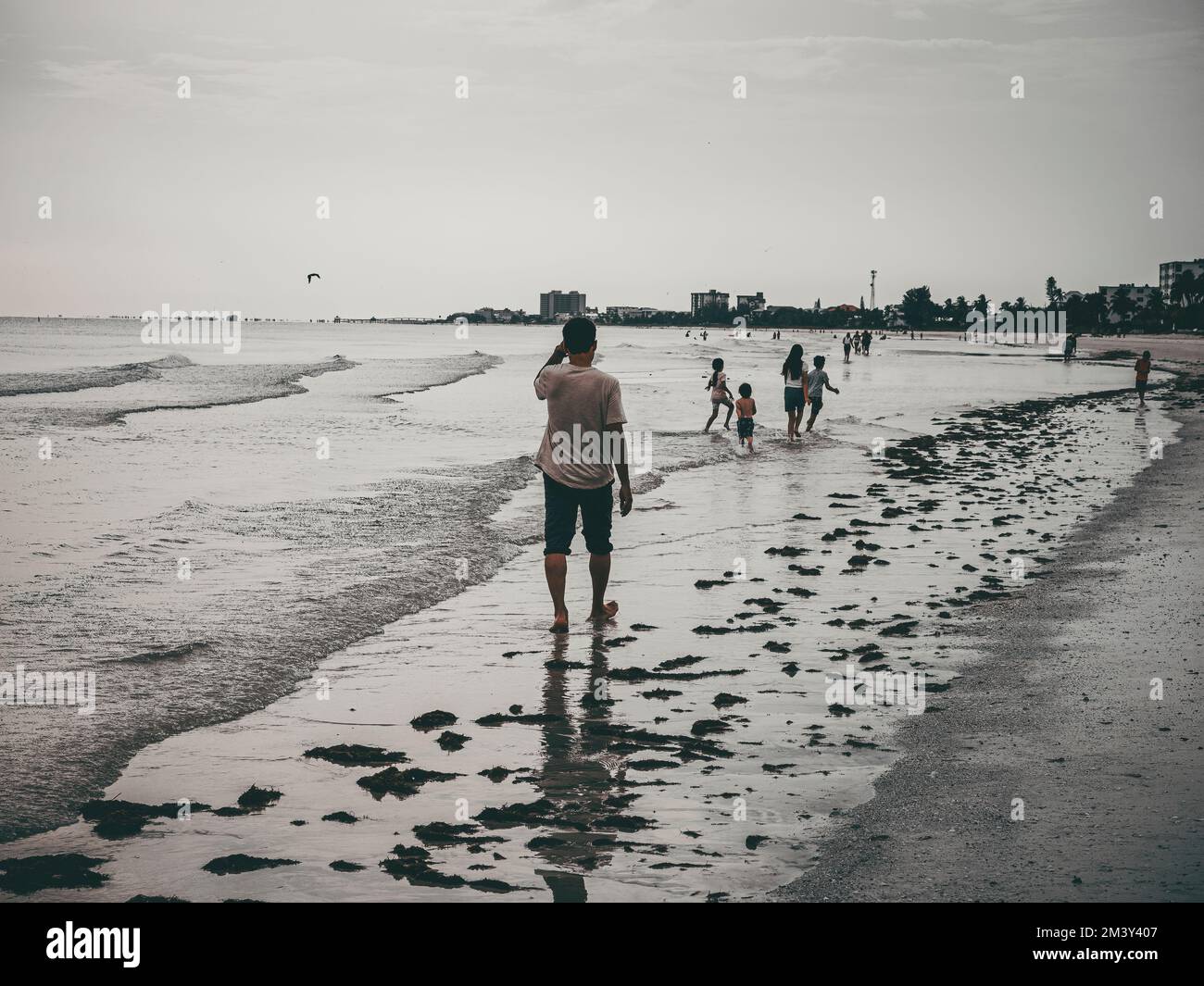 The people walking on a sandy beach at low tide Stock Photo - Alamy
