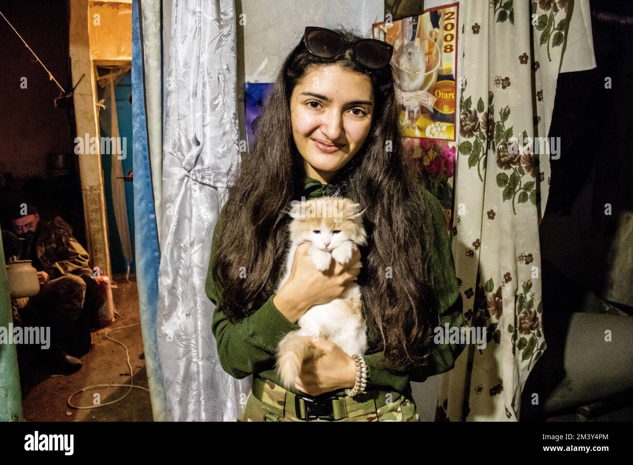Portrait of Manushak affectionately posing with her cat in a combat ...