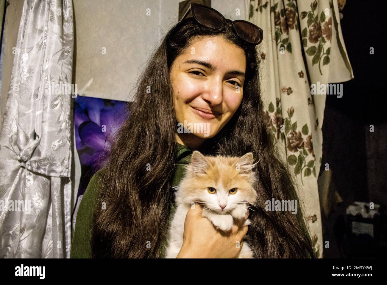 Portrait of Manushak affectionately posing with her cat in a combat ...
