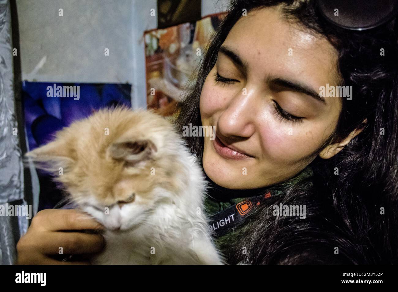 Portrait of Manushak affectionately posing with her cat in a combat ...
