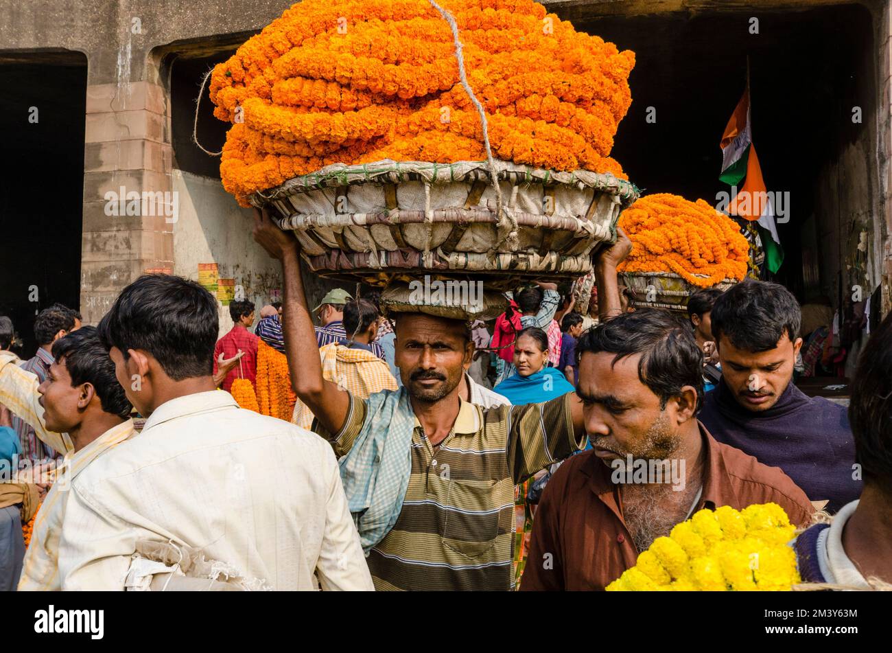 A porter is carrying a basket. The 125-year old Kolkata Flower Market ...