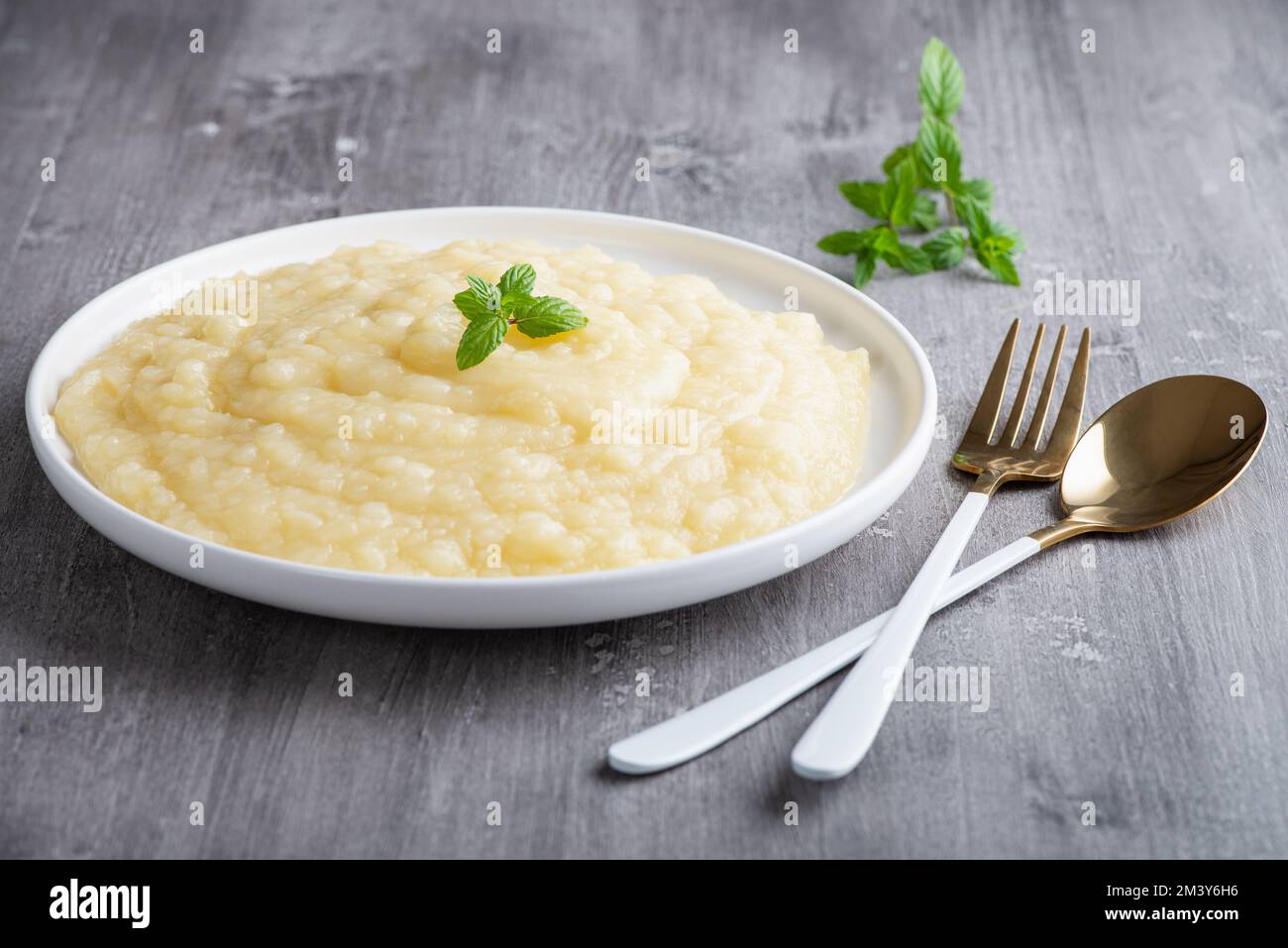 Mashed potatoes in white plate on gray wooden background Stock Photo ...