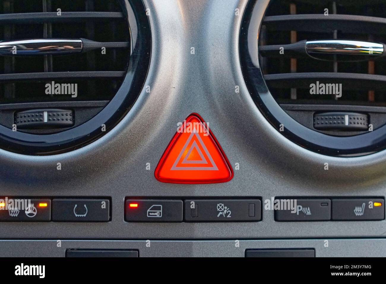 Illuminated red hazard safety triangle button in vehicle Stock Photo ...