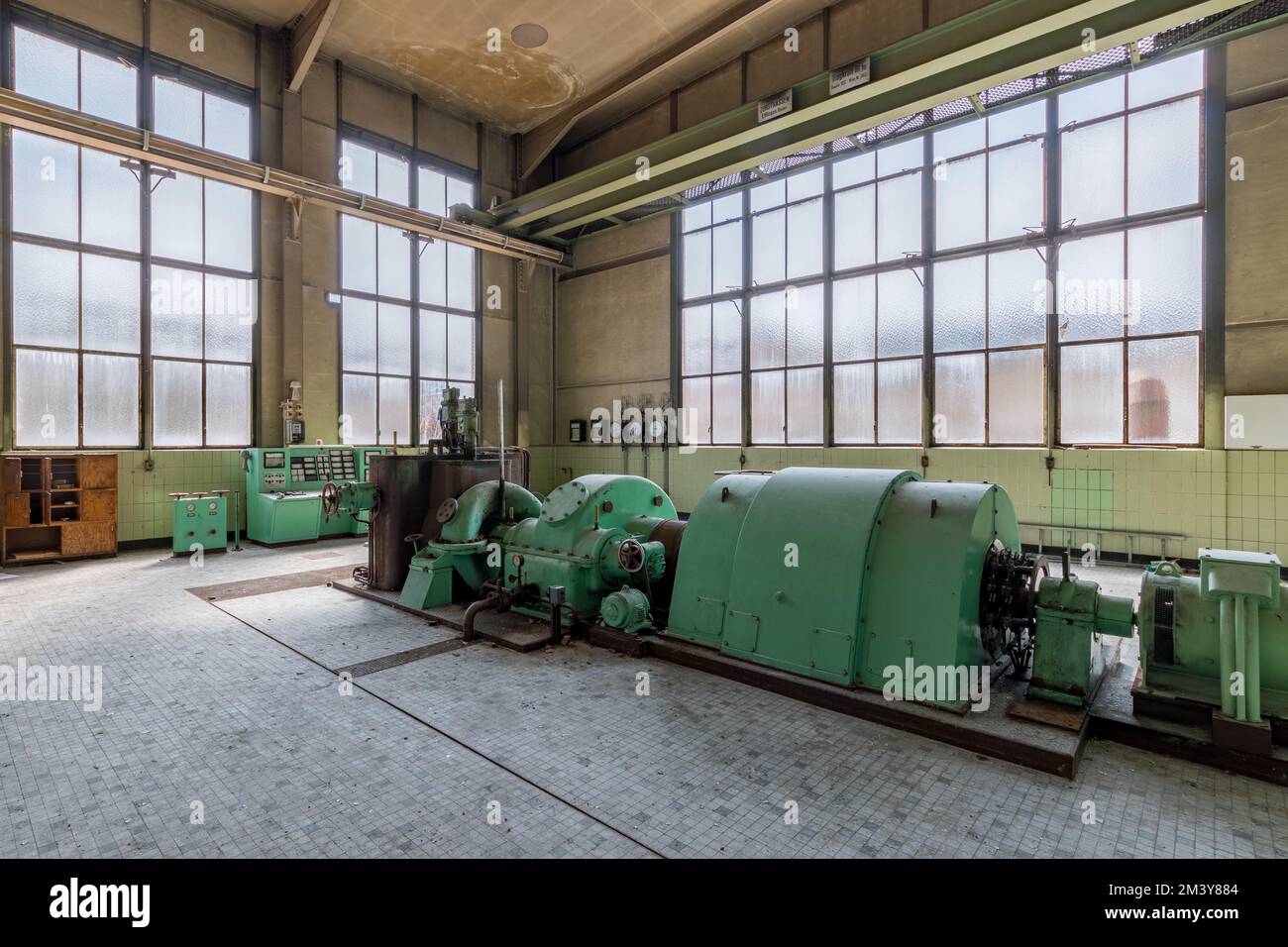 The interior of generator room with a turbine in a decommissioned power ...