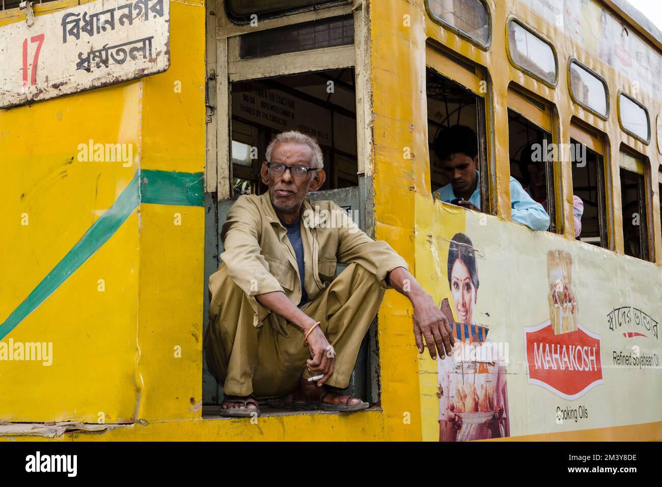 Driver of an old Kolkata tram having rest at a red traffic-light Stock ...