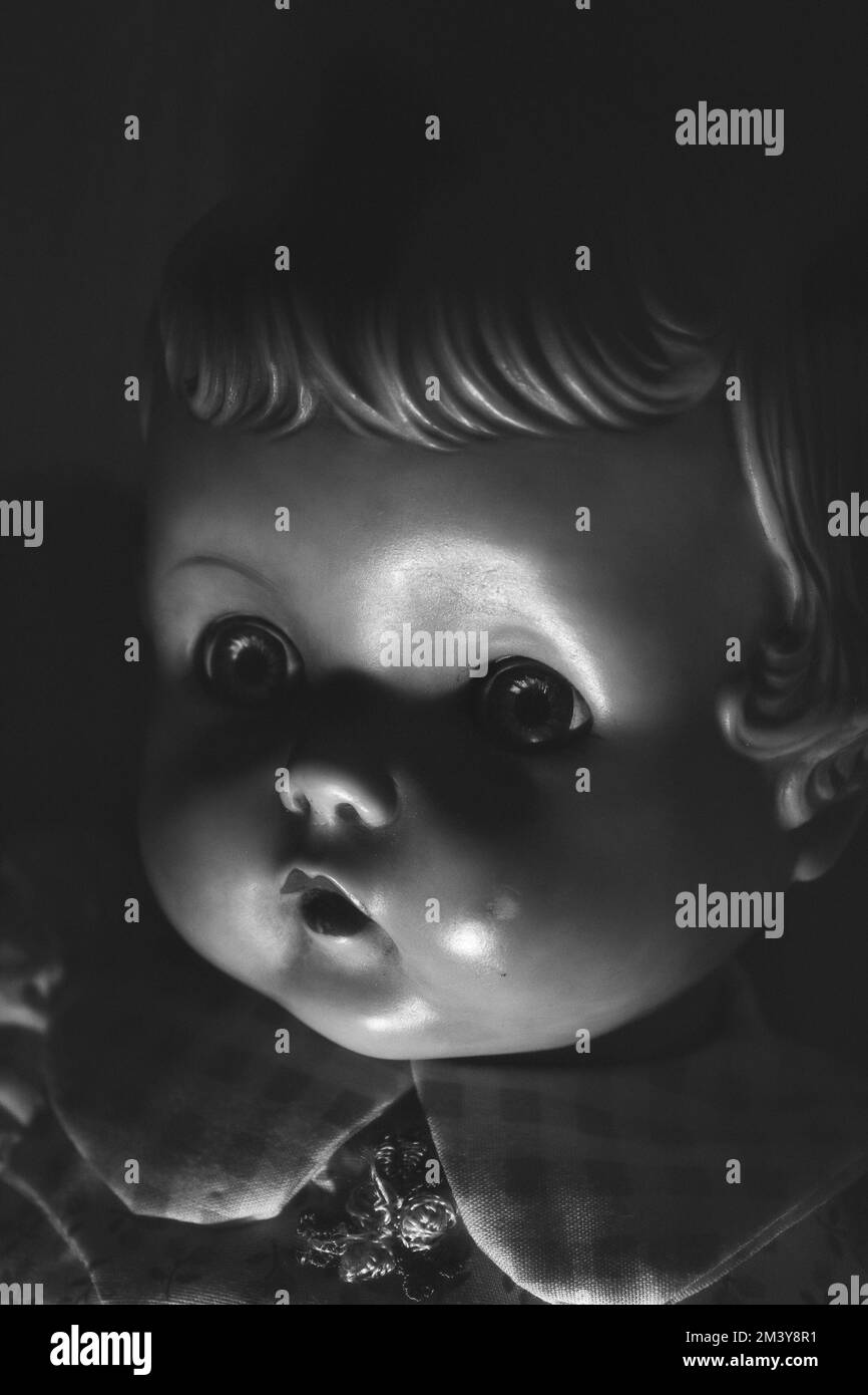 Bright light and shadows on an antique doll face in a dark room Stock ...