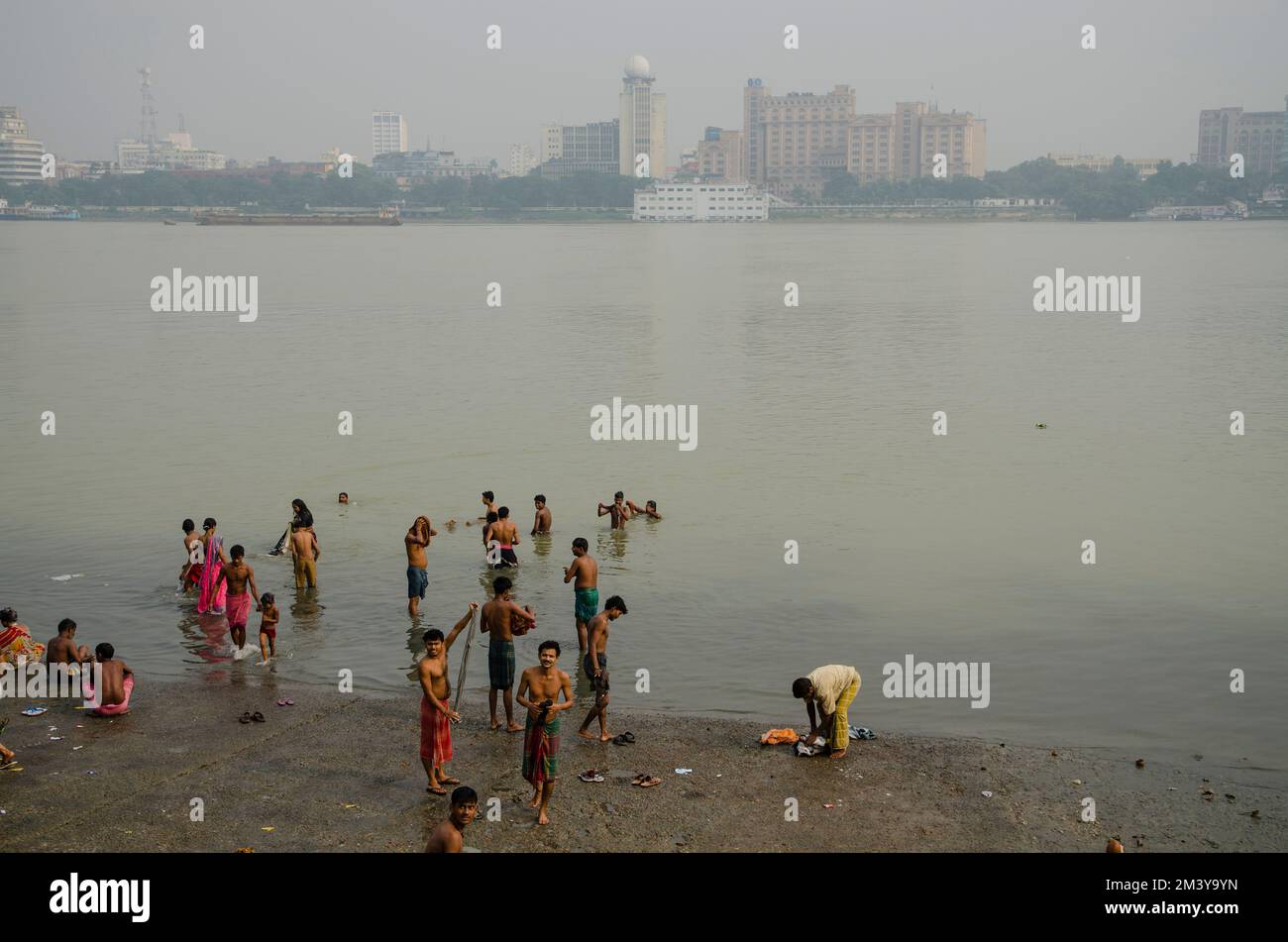 People taking bath in the river Hooghly, Kolkata on the opposite side ...