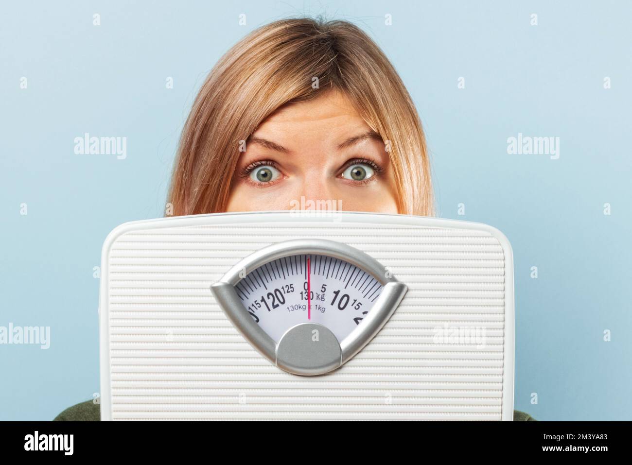 Surprised woman with white scales on blue background. Weight loss ... Surprised woman with white scales on blue background. Weight loss ...