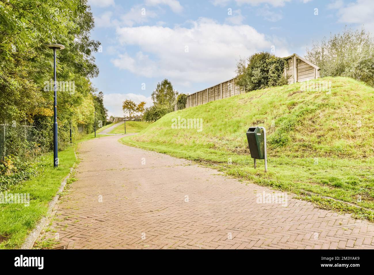 an empty path in the park, with green grass and trees on either sides ...