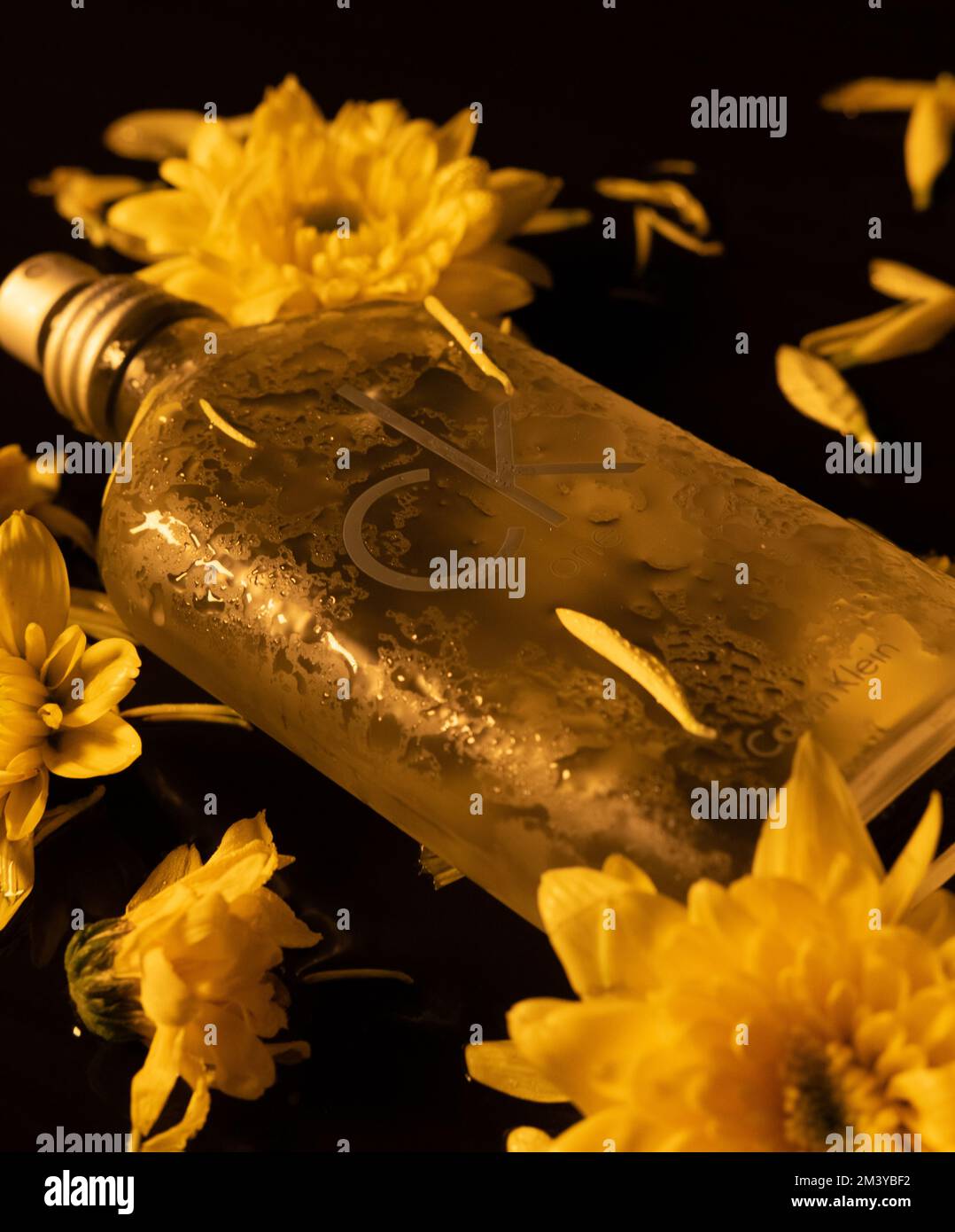 A vertical shot of the Calvin Klein One perfume with flower decorations ...