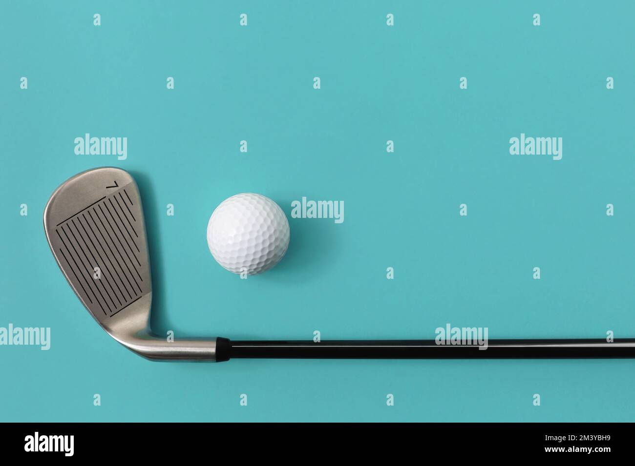 Golf club and golf ball isolated on light turquoise green background ...