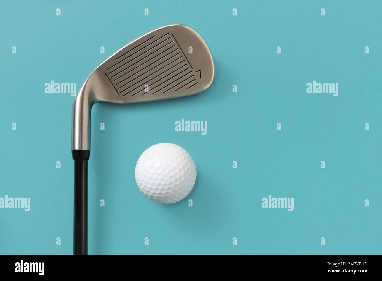 Detail of golf club and golf ball isolated on light turquoise blue ...
