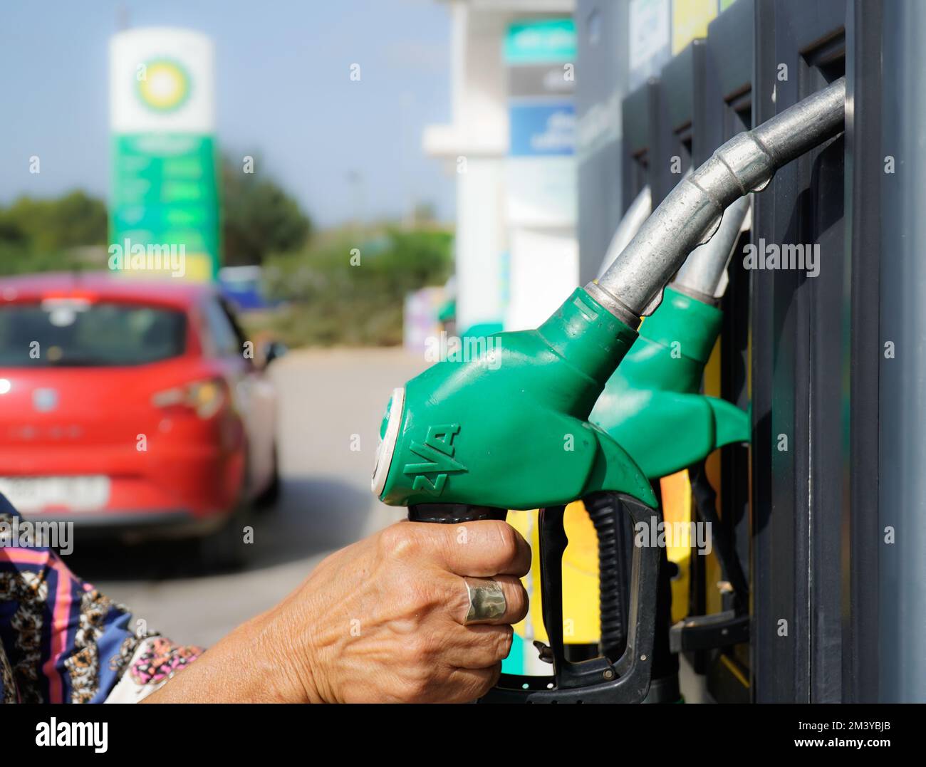 Woman filling up the diesel tank at the gas station. Oil price. Crisis ...