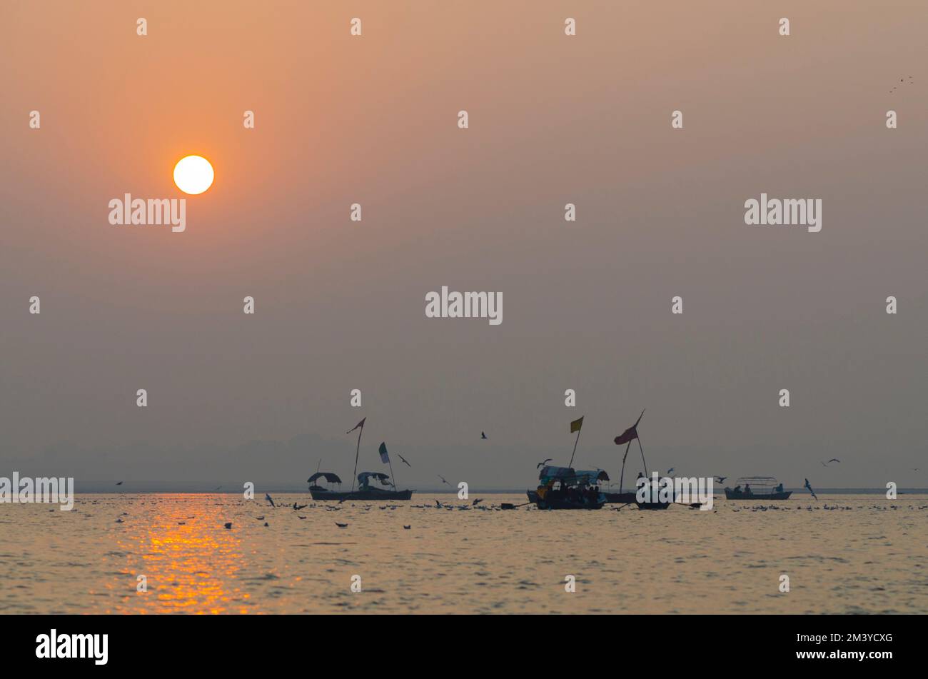 Sunrise over boats with pilgrims at Sangam, the confluence of the holy ...