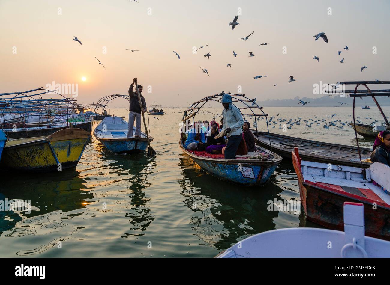 Sunrise over boats with pilgrims at Sangam, the confluence of the holy ...