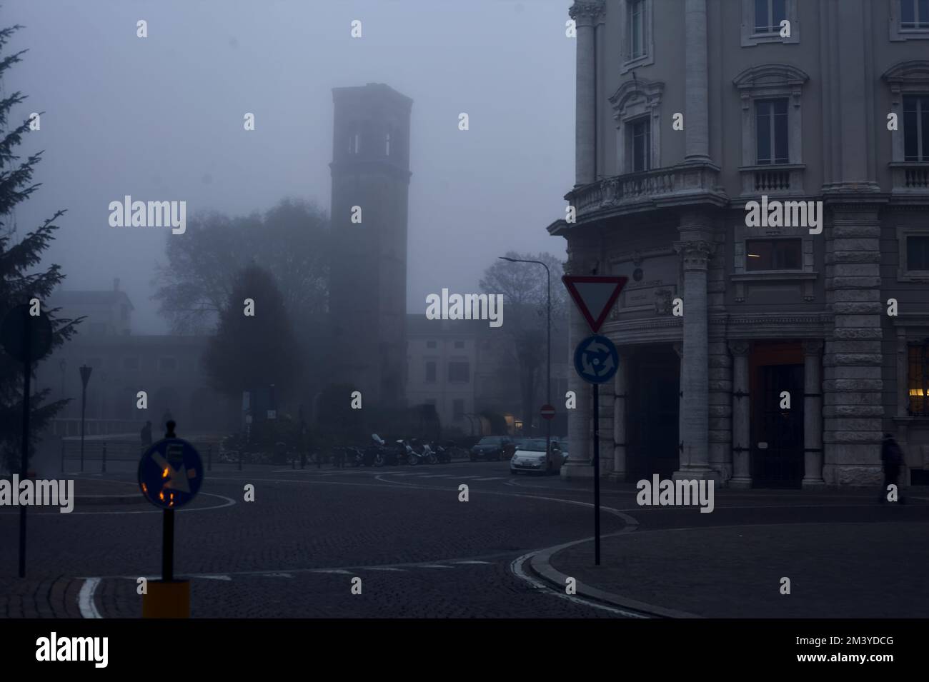 Square with buildings and a tower in the fog Stock Photo - Alamy