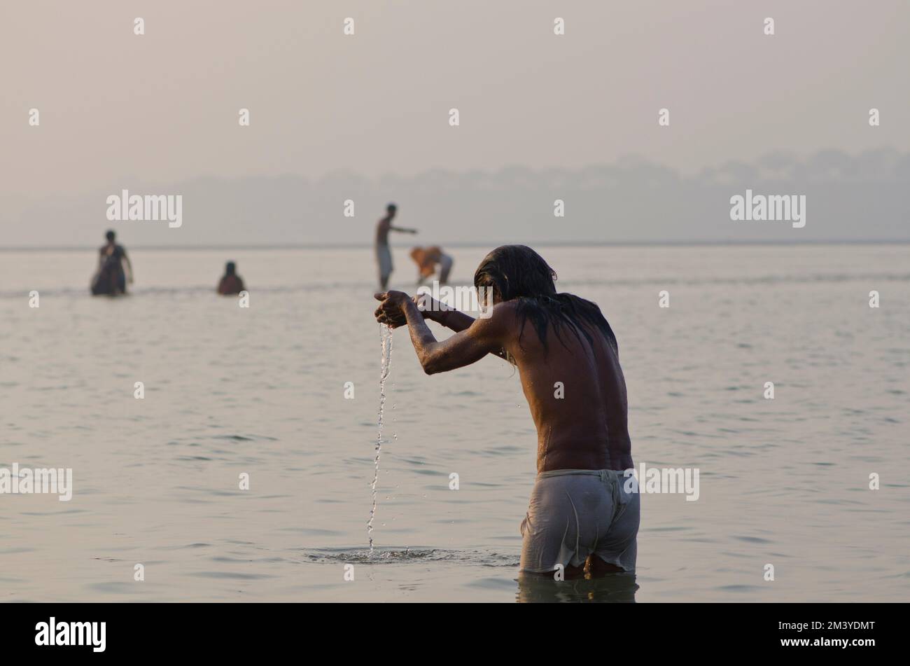 Pilgrim praying at Sangam, the confluence of the holy rivers Ganges ...