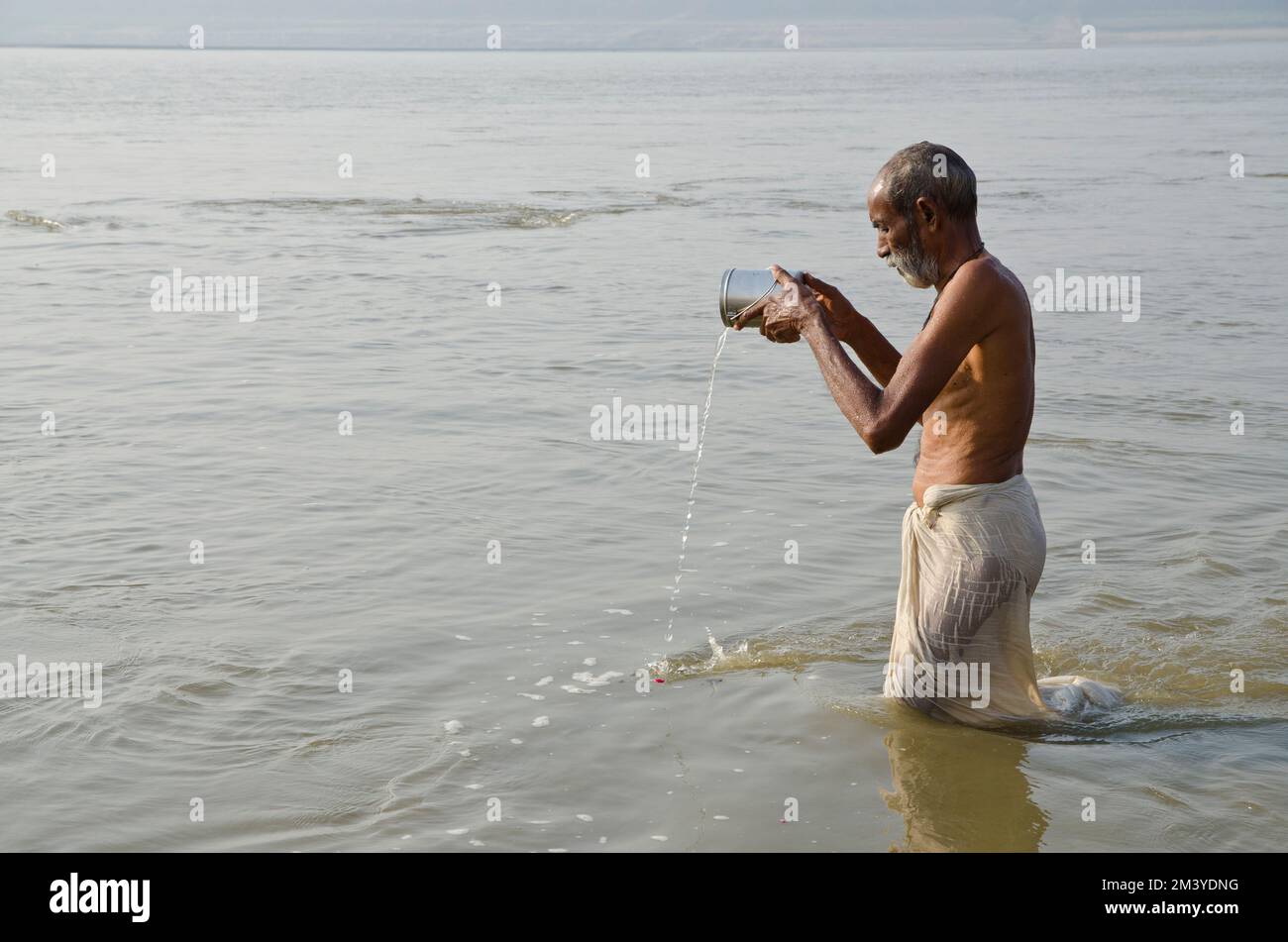Pilgrim praying at Sangam, the confluence of the holy rivers Ganges ...