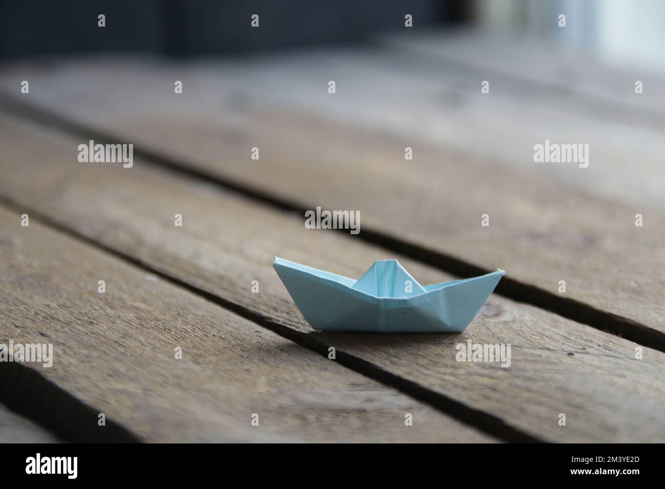 Beautiful paper boat on a vintage wooden background Stock Photo - Alamy