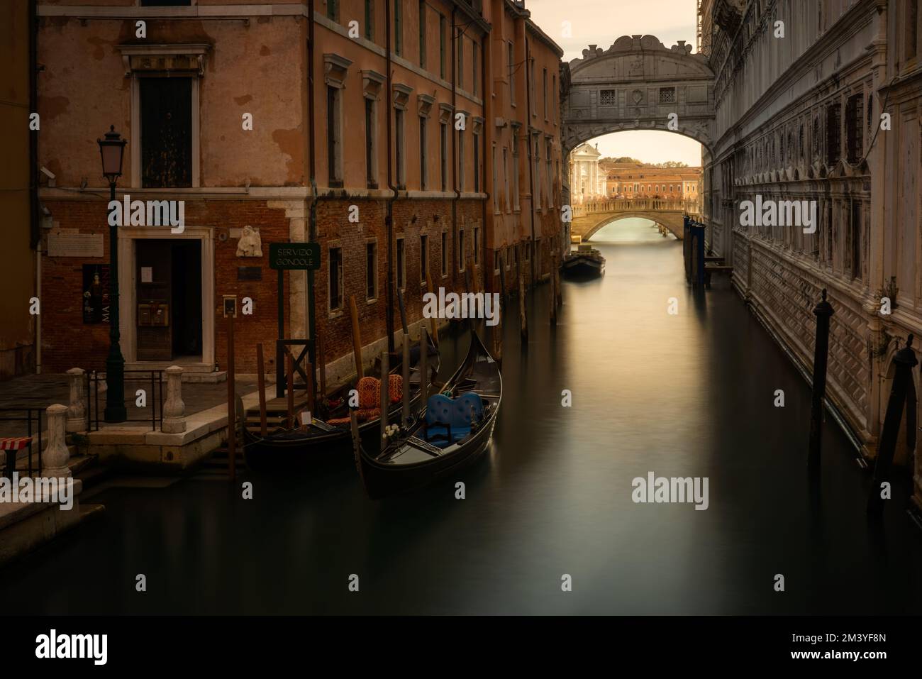 Two gondolas in Venezia canal with two bridges in background, Italy ...