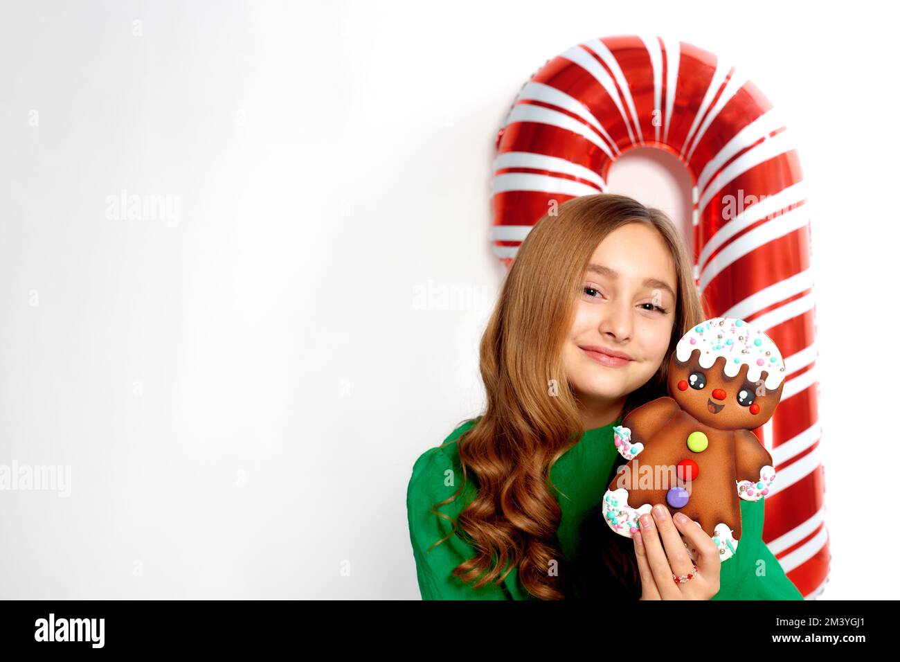fancy girl holds Christmas gingerbread man on inflatable shape of candy ...