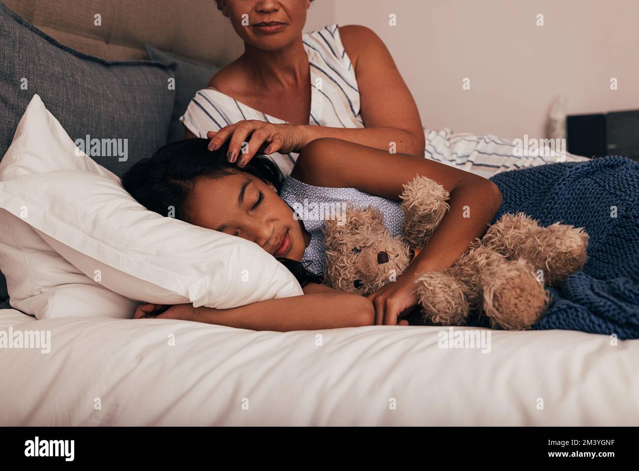 Mature Woman Adjusting The Hair Of Her Granddaughter While She Sleeping