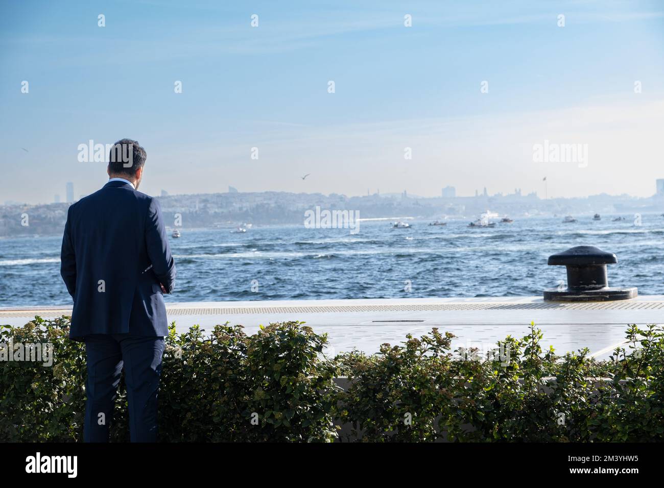 Young man standing watching the sea Stock Photo - Alamy