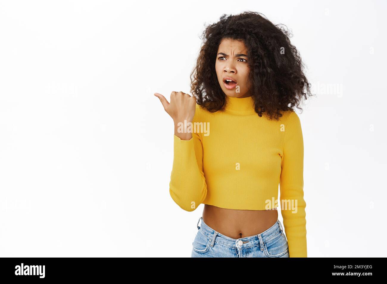 Confused african american woman, 25 years old, pointing and looking ...