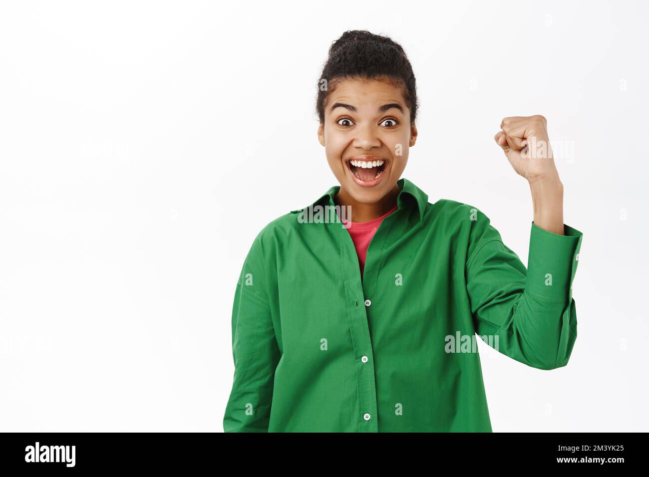 Enthusiastic young girl say hooray, raise hand up and chants ...