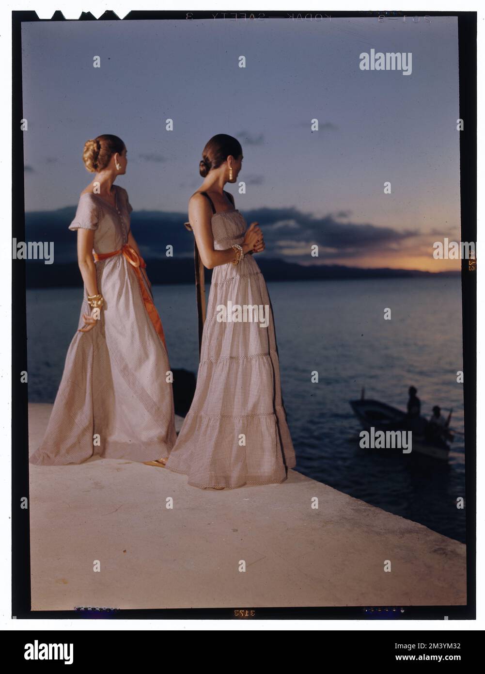 Two women in evening gowns posed in front of water at sunset, Toni ...